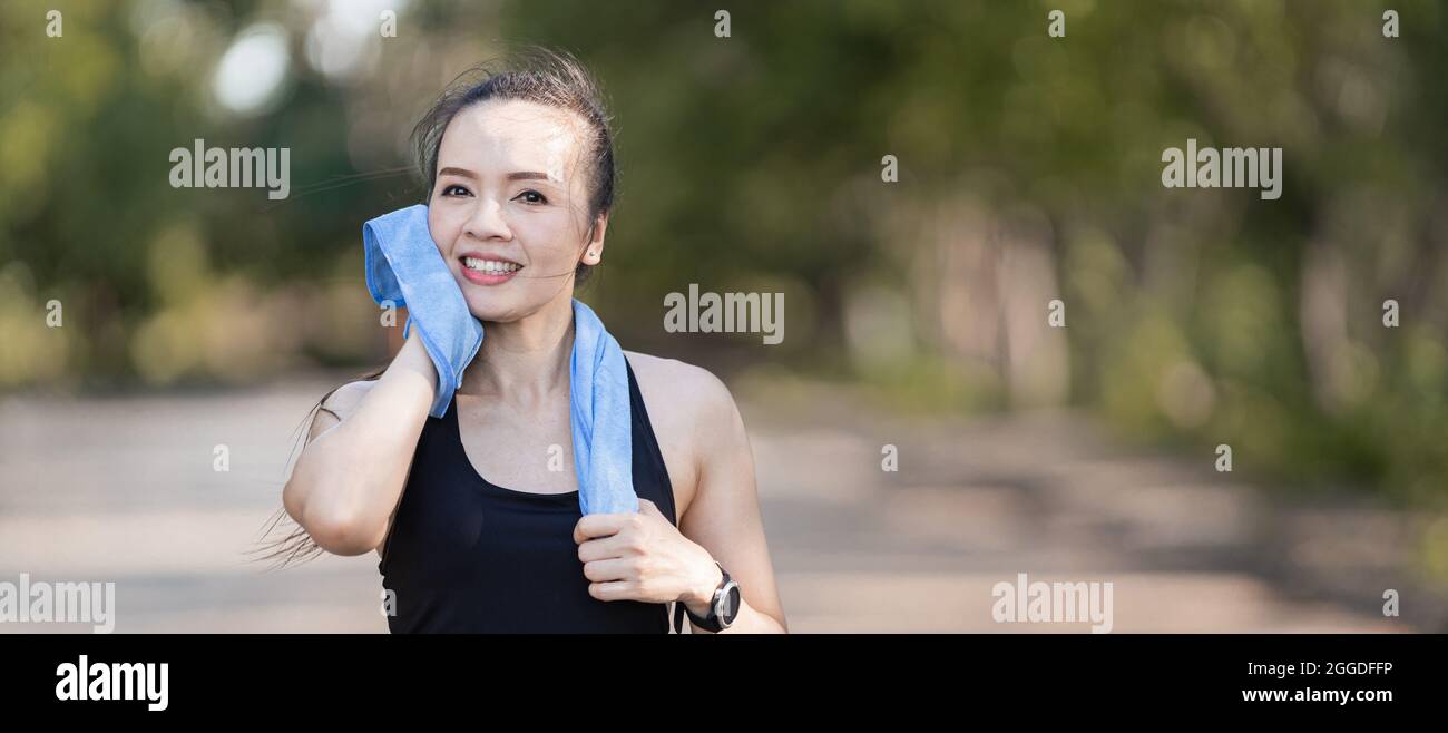 Southeast Asian female runner in black sports attire jogging in the ...