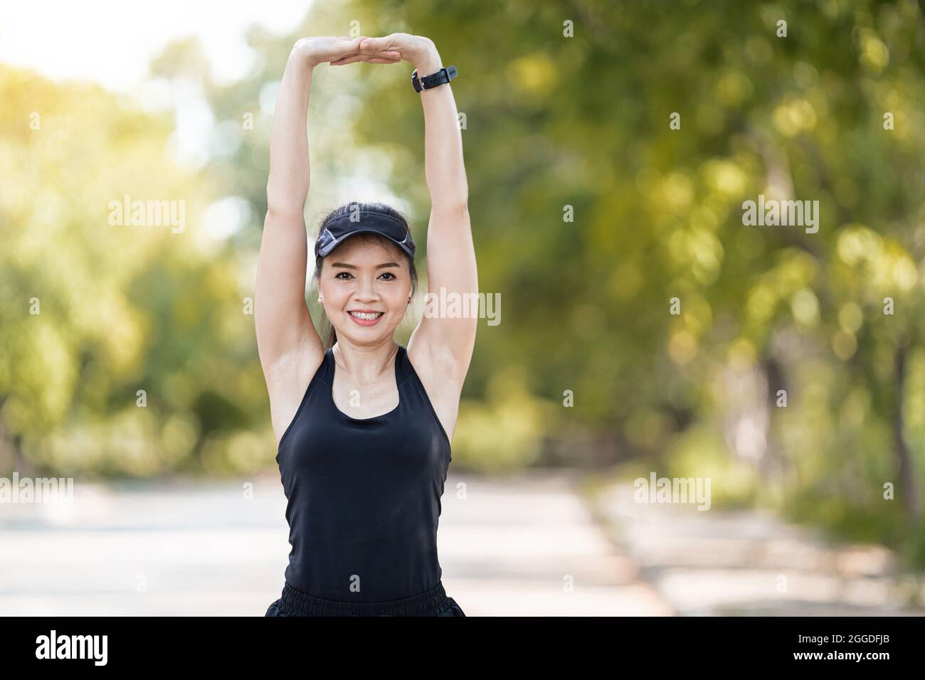 Cheerful Southeast Asian female runner in sports attire do some ...