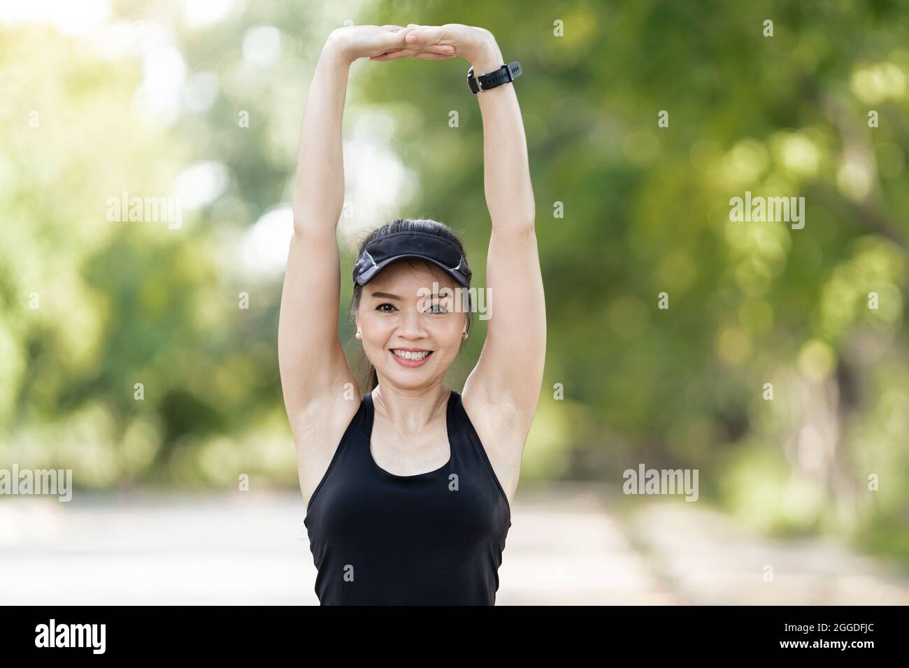 Cheerful Southeast Asian female runner in sports attire do some ...