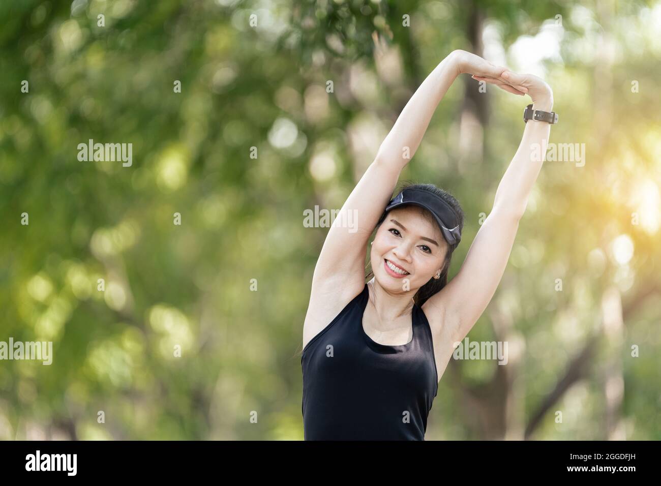 Cheerful Southeast Asian female runner in sports attire do some ...