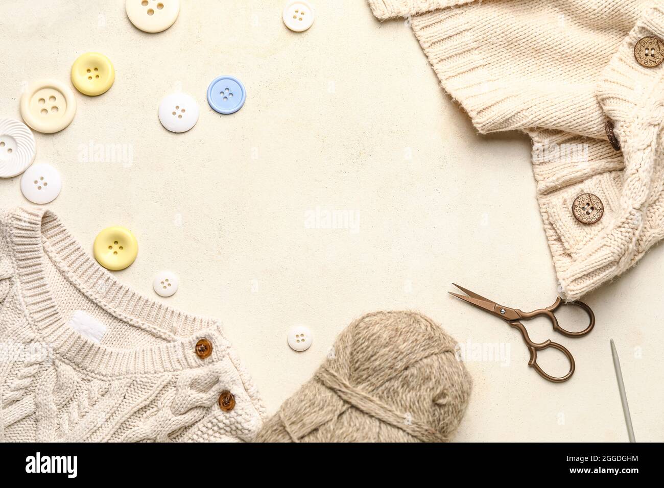 Frame made of clothes, knitting yarn and buttons on white background ...