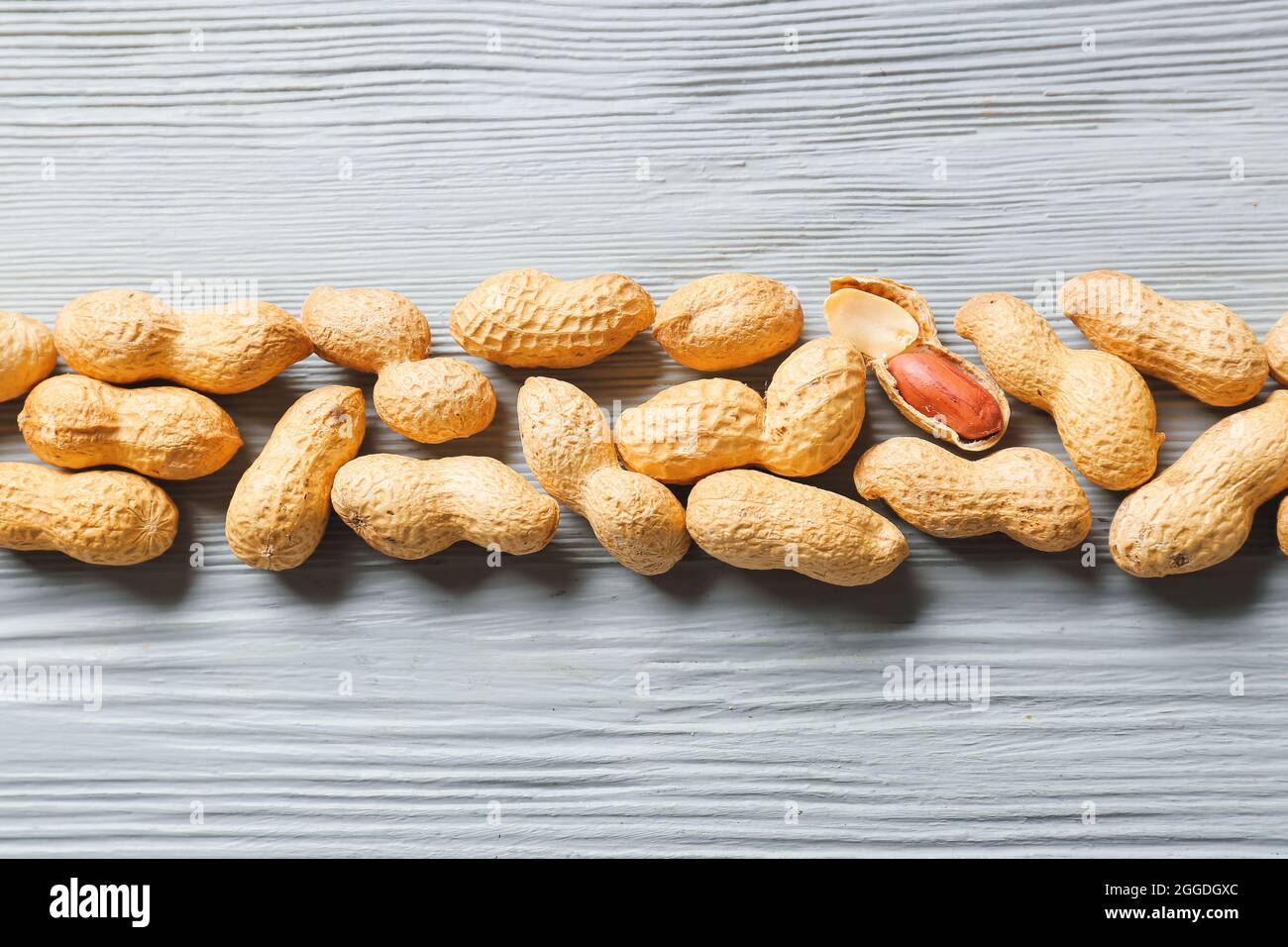 Tasty peanuts on light wooden background. Concept of uniqueness Stock ...