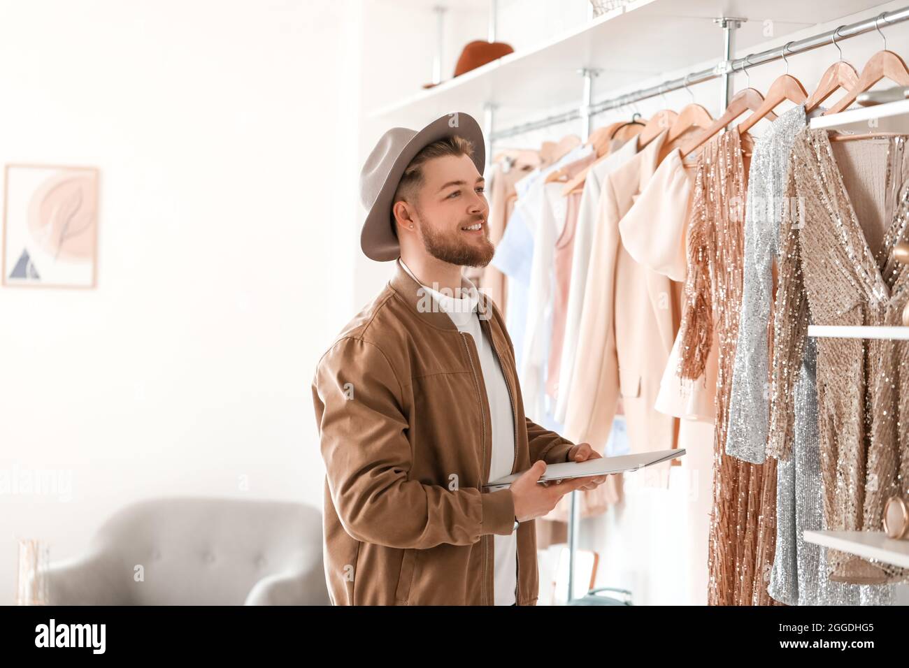 Male stylist with laptop working in studio Stock Photo - Alamy