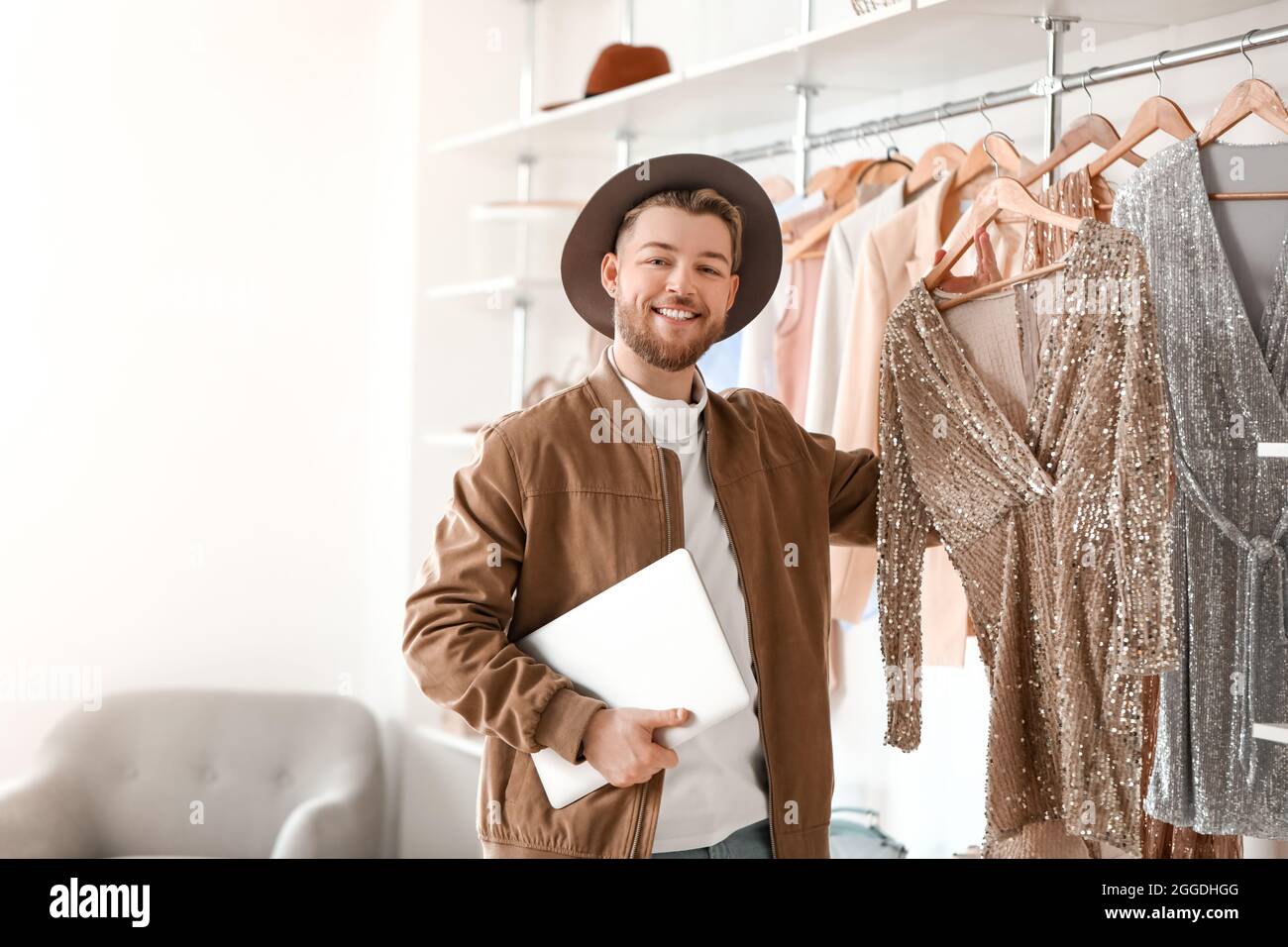 Male stylist with laptop working in studio Stock Photo - Alamy