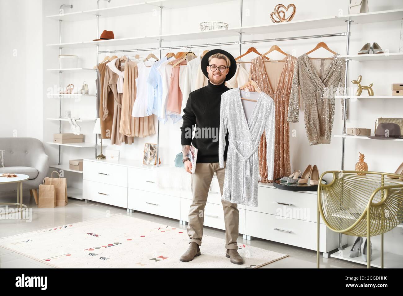 Male stylist with clothes in studio Stock Photo - Alamy