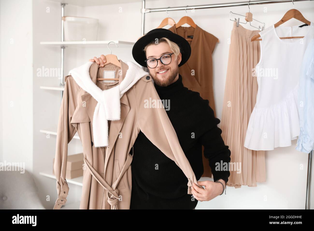 Male stylist with clothes in studio Stock Photo - Alamy