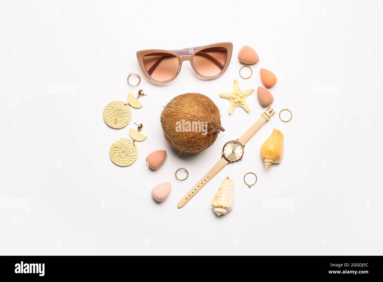 Composition with female accessories, coconut and seashells on white ...
