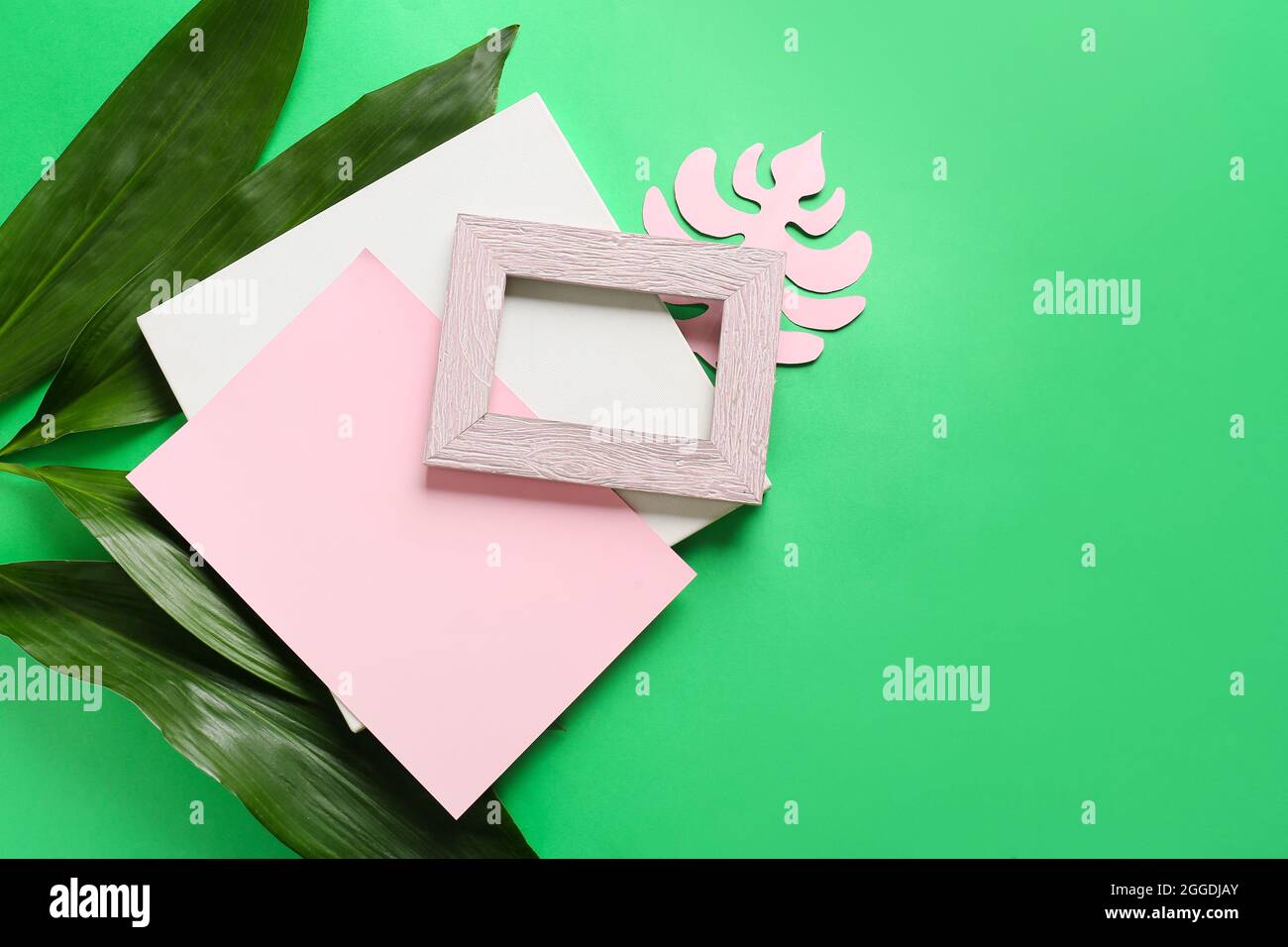 Composition with empty picture frame, blank card, poster and green ...