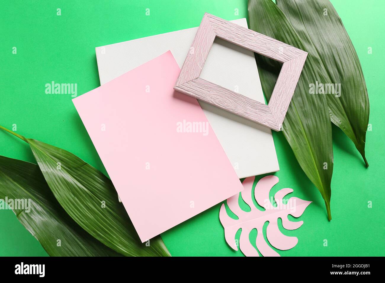 Composition with empty picture frame, blank card, poster and green ...