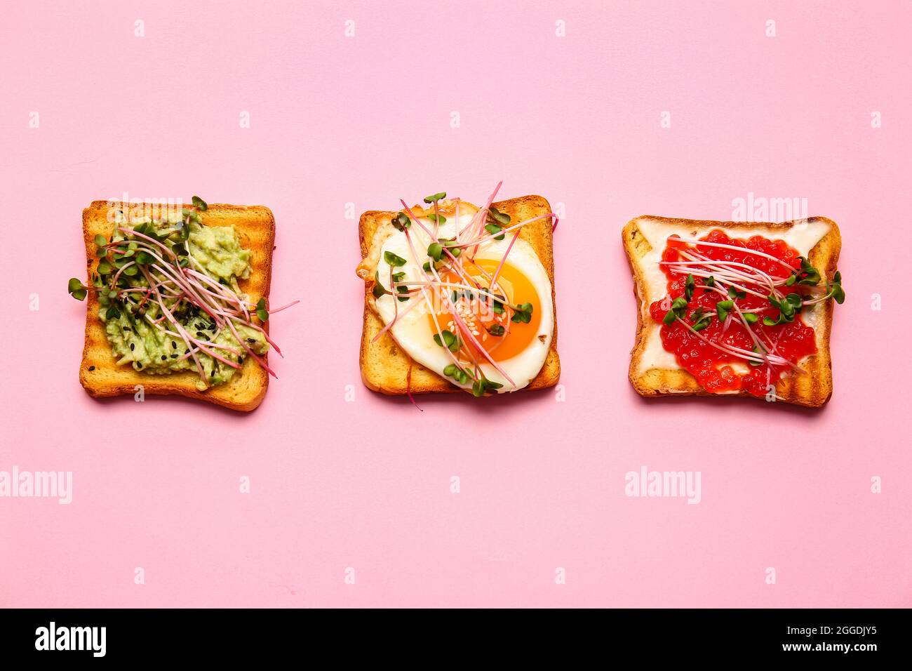 Different toasts with micro green on color background Stock Photo - Alamy