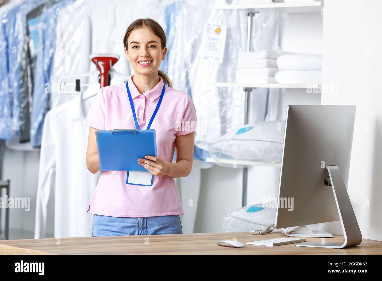 Female worker of modern dry-cleaner's at reception Stock Photo - Alamy