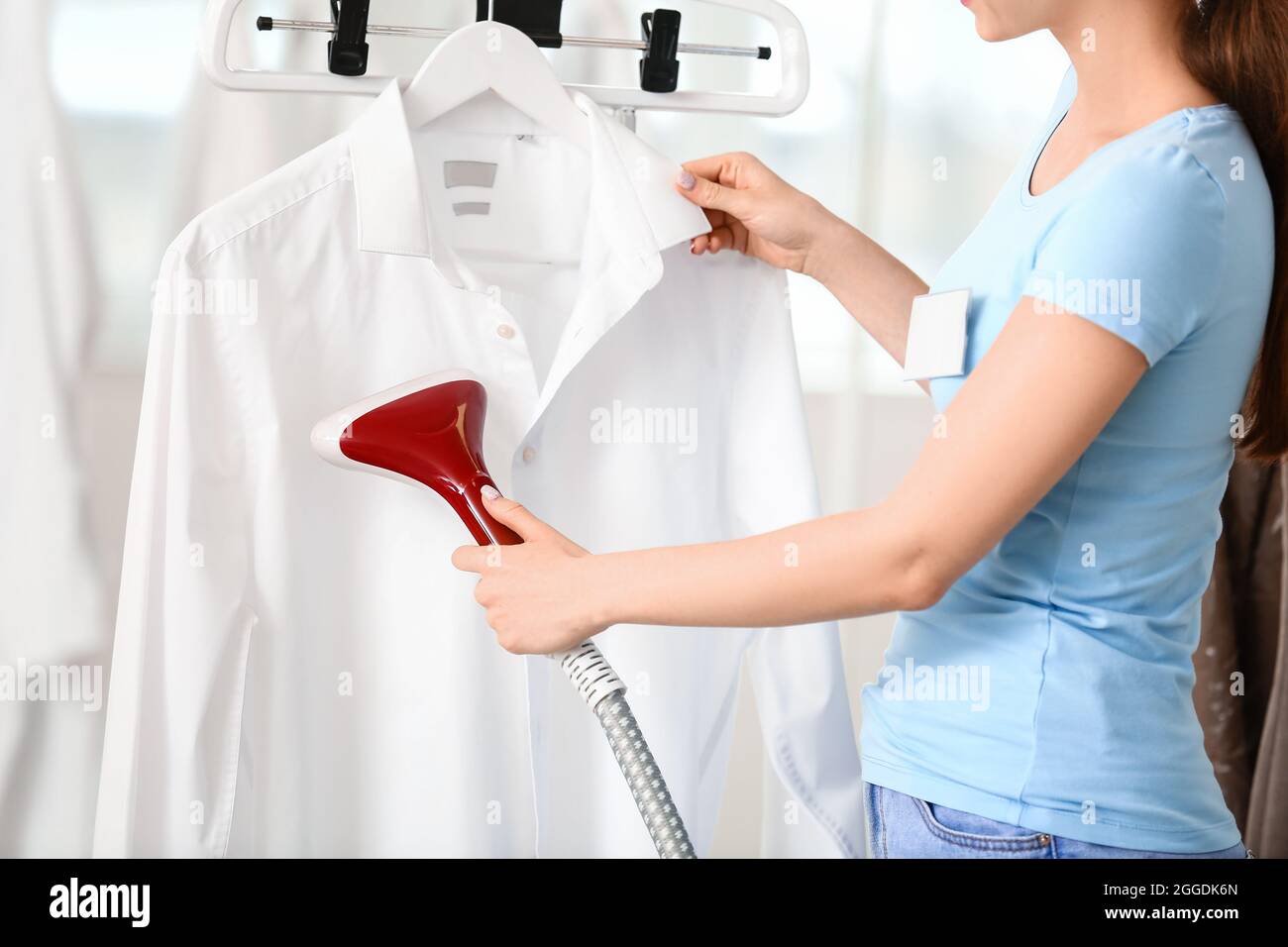 Female worker steaming clothes at modern dry-cleaner's Stock Photo - Alamy