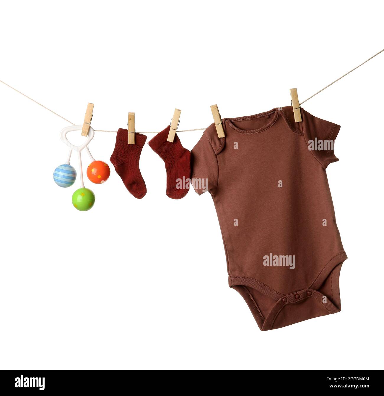 Baby clothes and toy hanging on rope against white background Stock ...