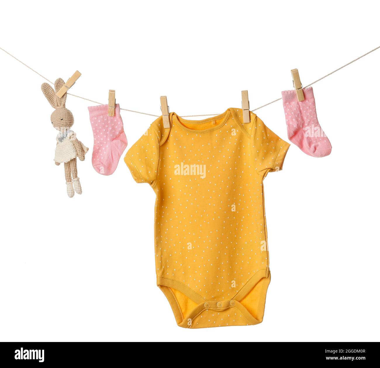 Baby clothes and toy hanging on rope against white background Stock ...