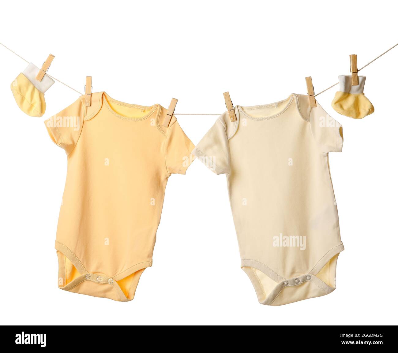 Baby clothes hanging on rope against white background Stock Photo - Alamy