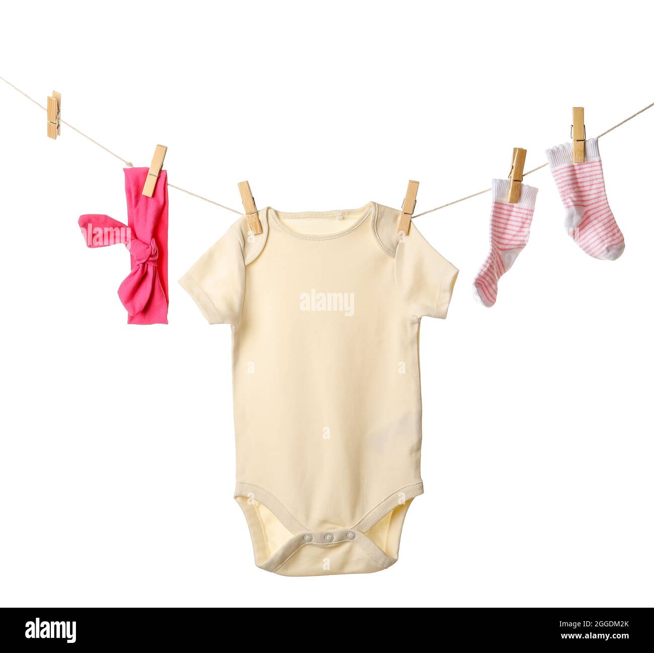 Baby clothes and headband hanging on rope against white background ...