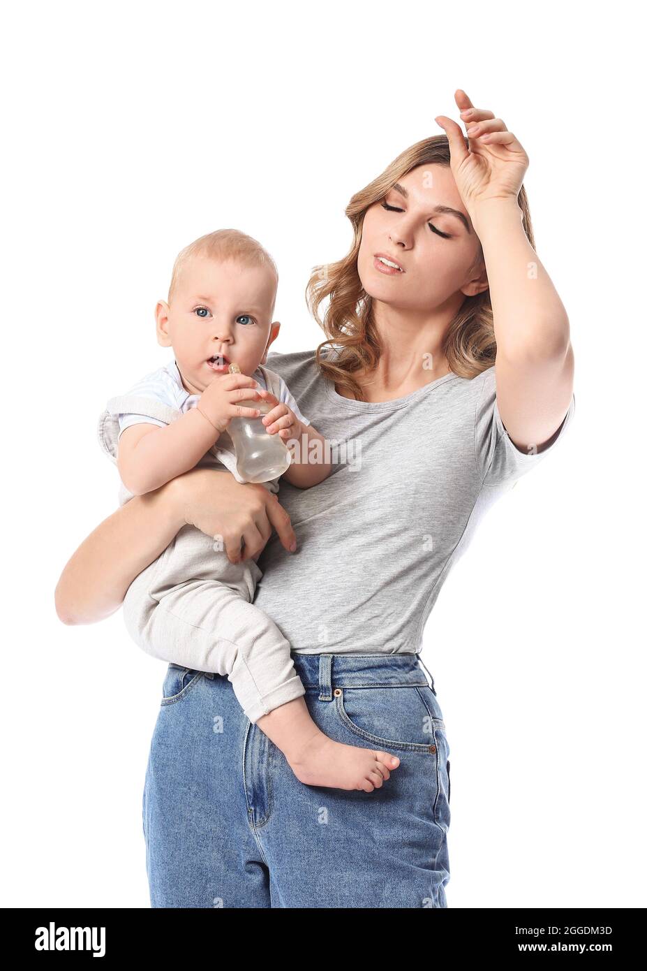 Tired young mother giving water to her cute baby on white background ...