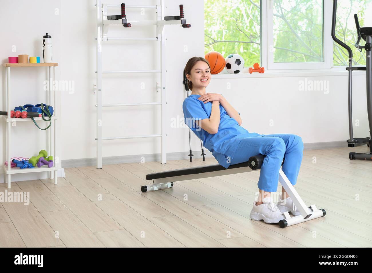 Female physiotherapist demonstrating exercise in rehabilitation center ...
