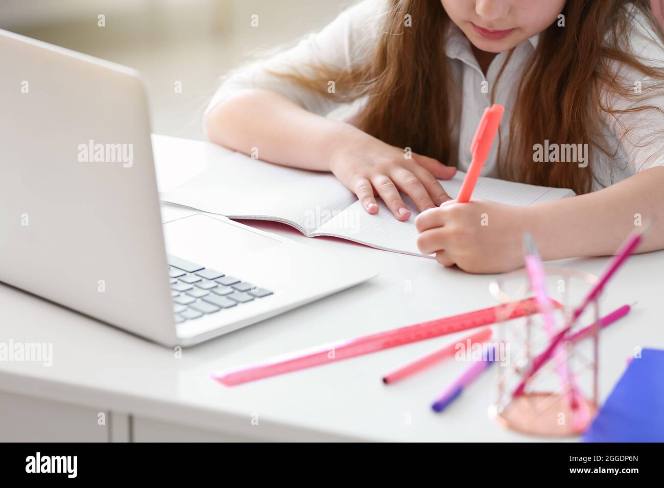 Little girl doing lessons online at home Stock Photo - Alamy