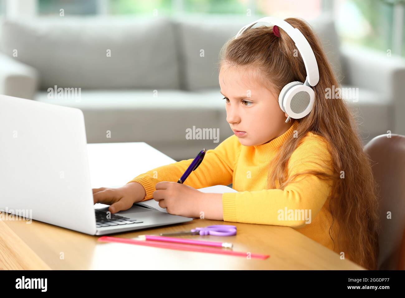 Little girl doing lessons online at home Stock Photo - Alamy