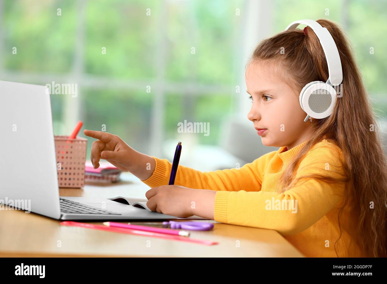 Little girl doing lessons online at home Stock Photo - Alamy