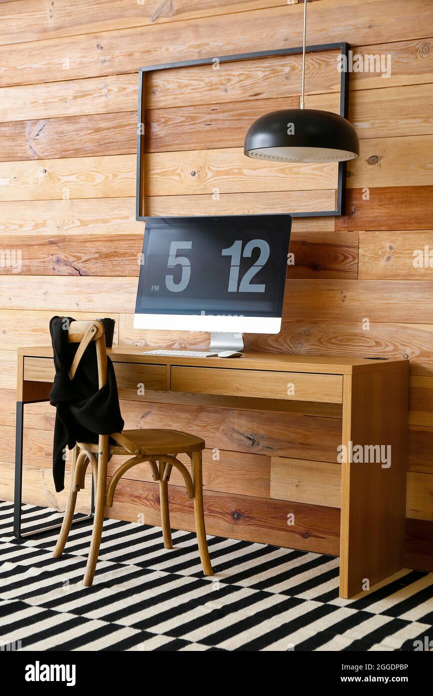 Modern workplace with computer near wooden wall Stock Photo - Alamy