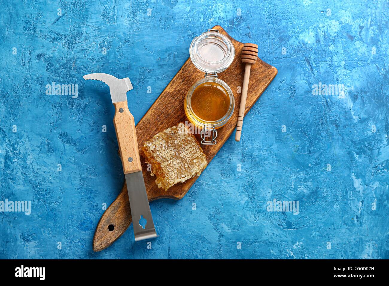 Bee frame lifter and honey on color background Stock Photo - Alamy