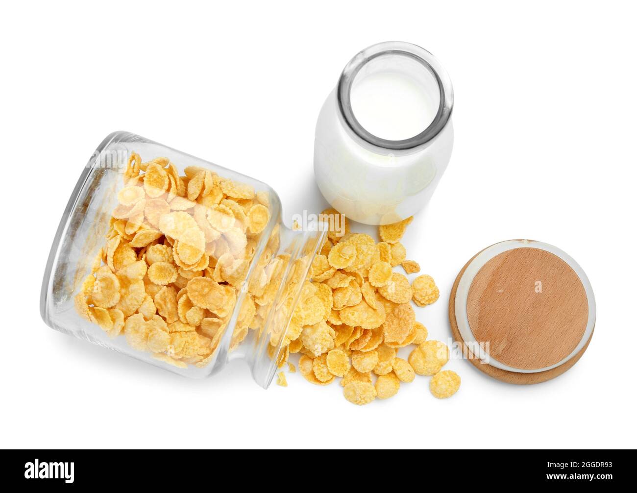 Glass jar with tasty cornflakes and bottle of milk on white background ...