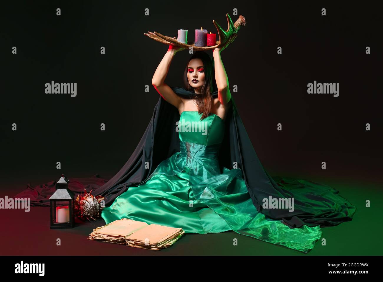 Young witch performing ritual on dark background Stock Photo - Alamy