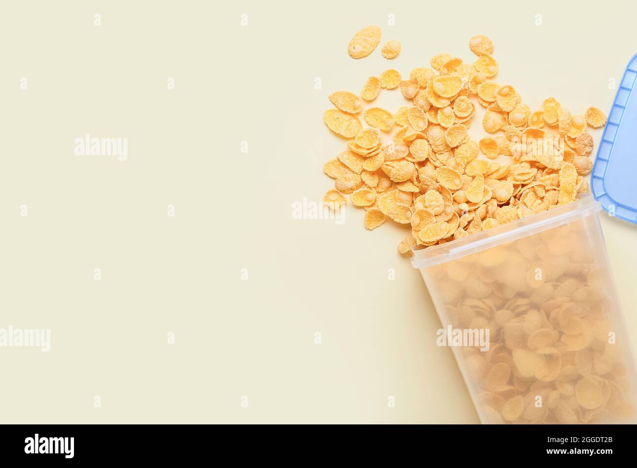 Container with tasty cornflakes on color background Stock Photo - Alamy