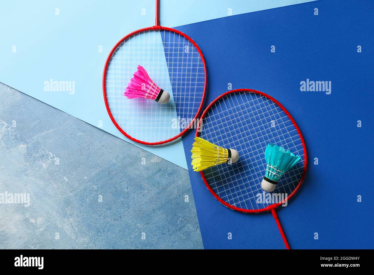 Badminton rackets and shuttlecocks on color background Stock Photo - Alamy