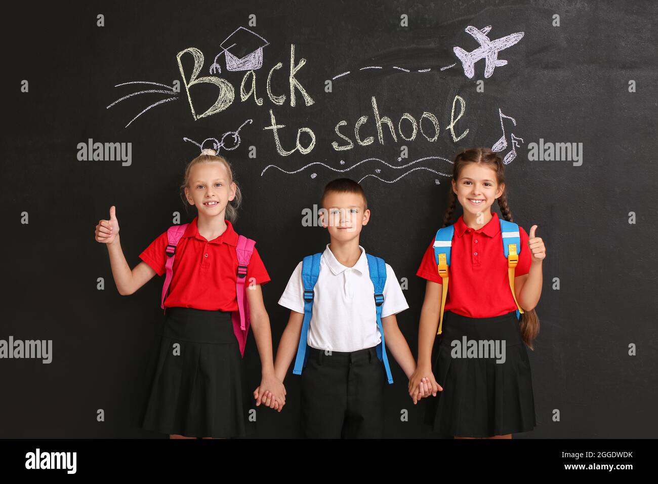 Cute pupils on dark background with text BACK TO SCHOOL Stock Photo - Alamy
