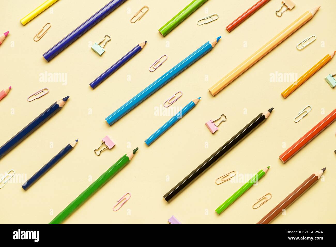 Pencils with paper clips on color background Stock Photo - Alamy