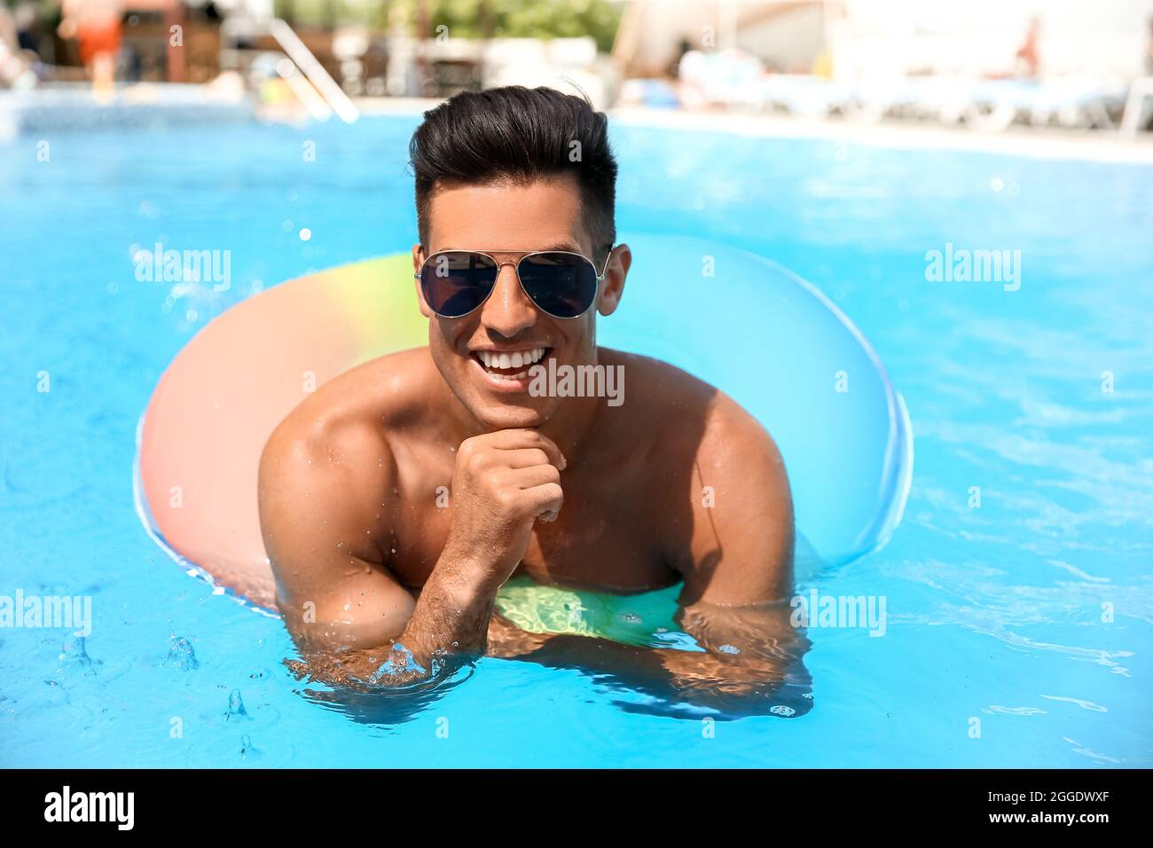 Young man with inflatable ring in swimming pool Stock Photo - Alamy