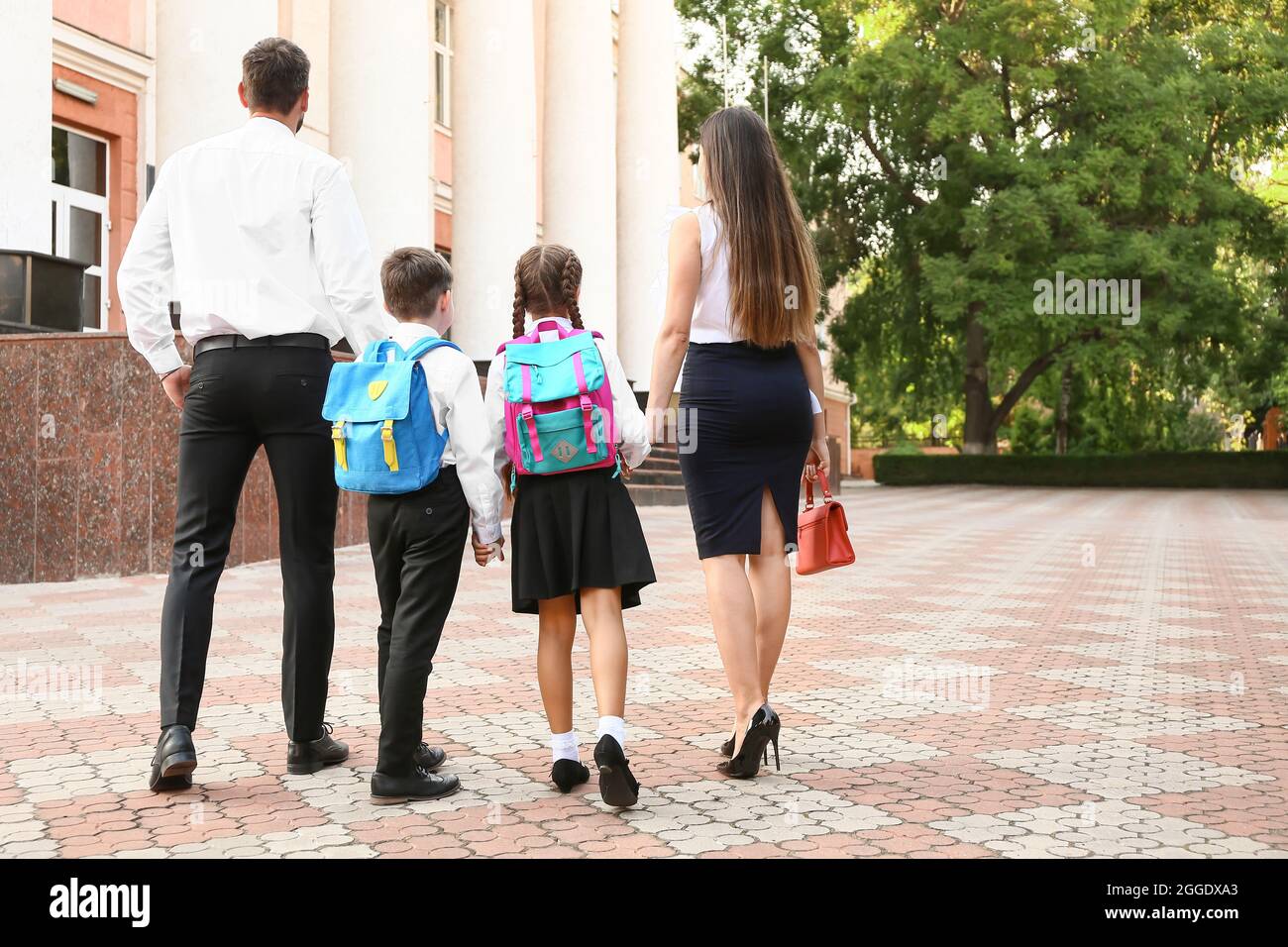 Cute little children going to school with their parents Stock Photo - Alamy