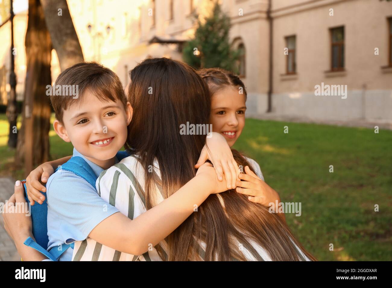 Mother saying goodbye to her little children near school Stock Photo ...