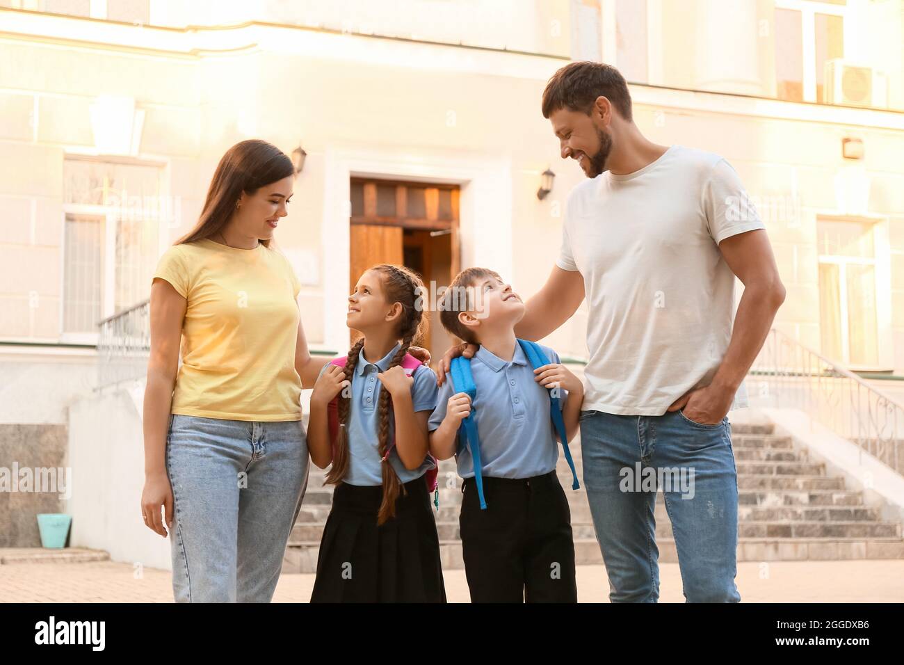 Cute little children going to school with their parents Stock Photo - Alamy