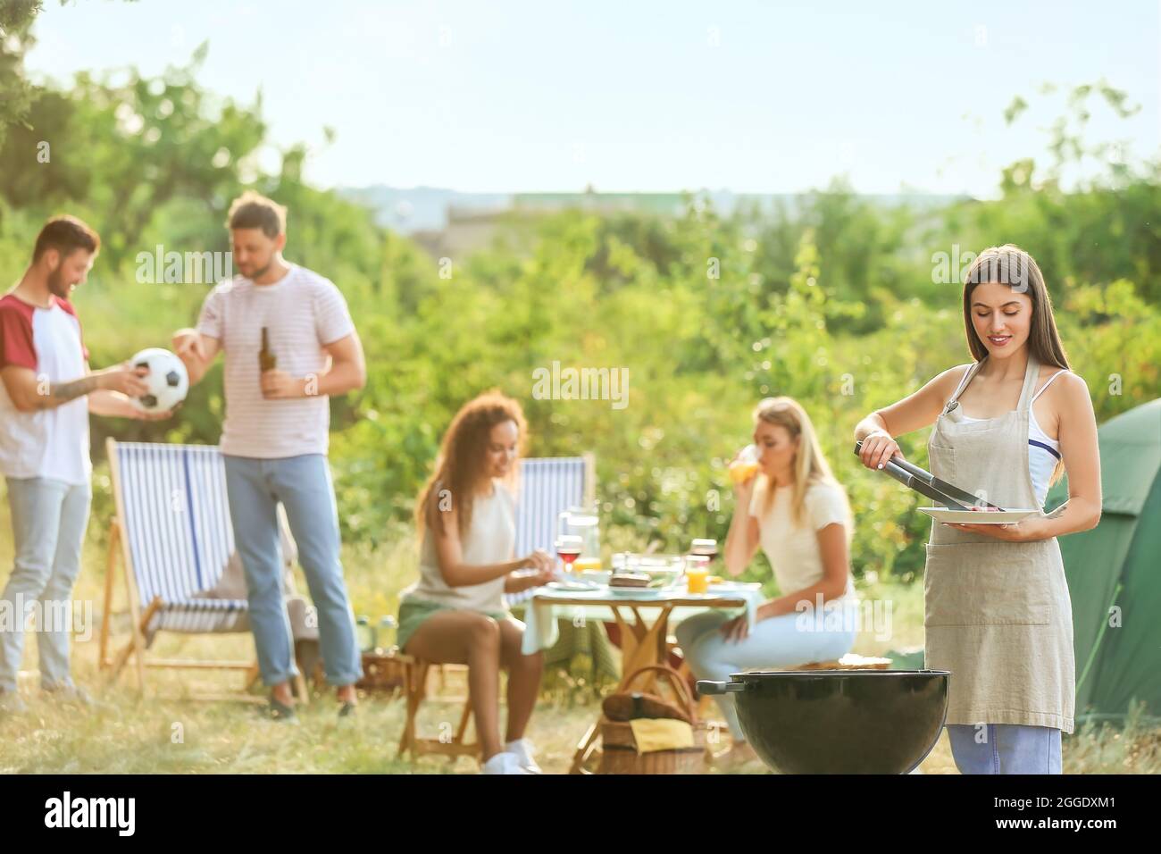 Young woman cooking food on barbecue grill outdoors Stock Photo - Alamy