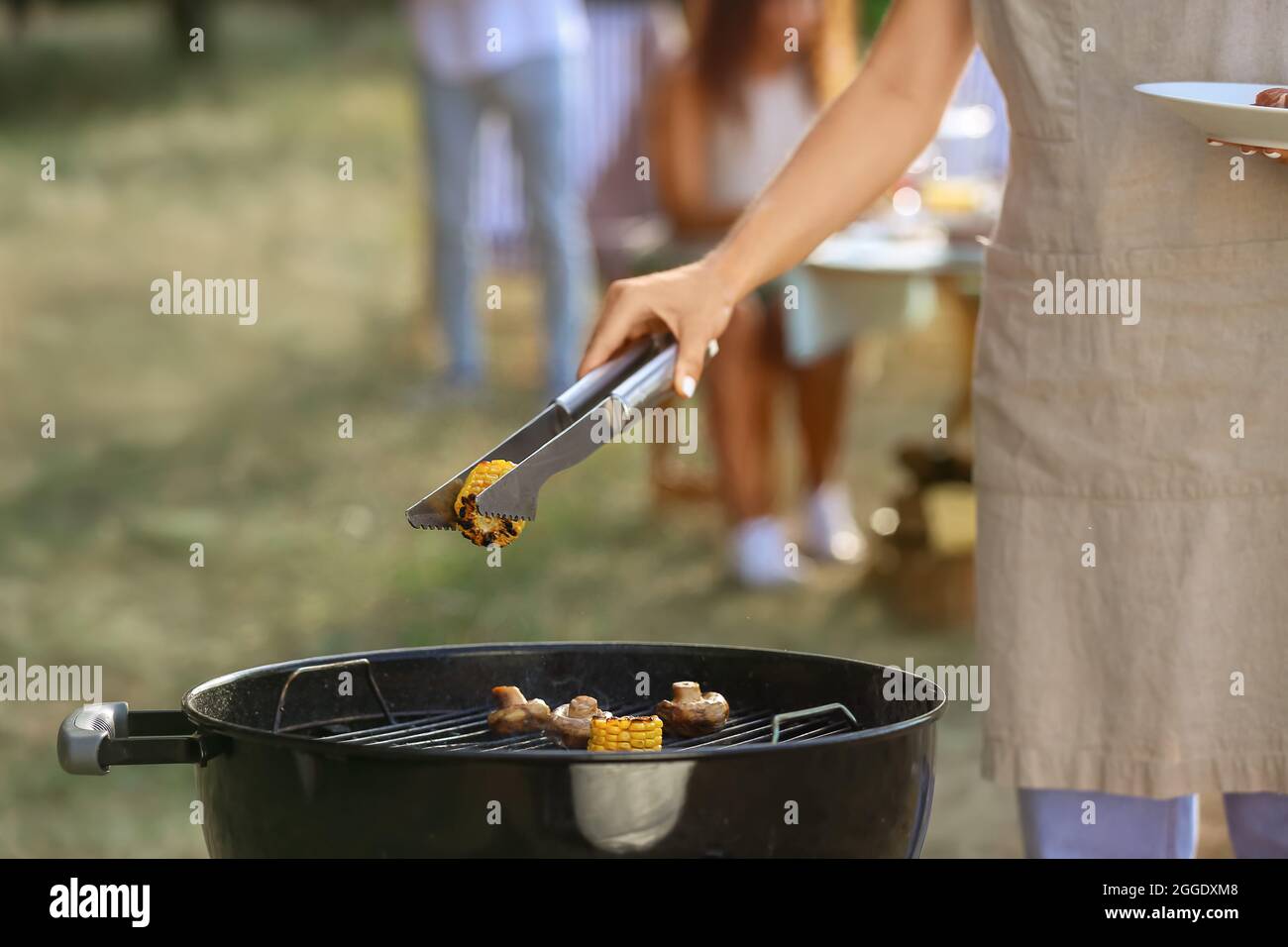 Young woman cooking food on barbecue grill outdoors Stock Photo - Alamy