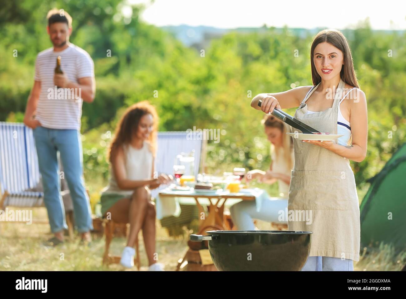 Young woman cooking food on barbecue grill outdoors Stock Photo - Alamy