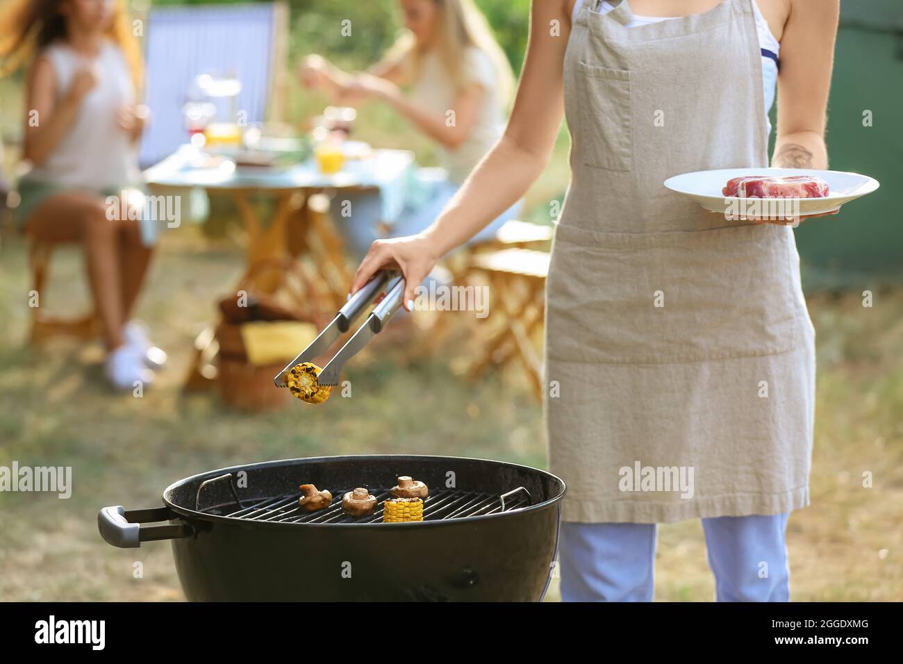 Young woman cooking food on barbecue grill outdoors Stock Photo - Alamy