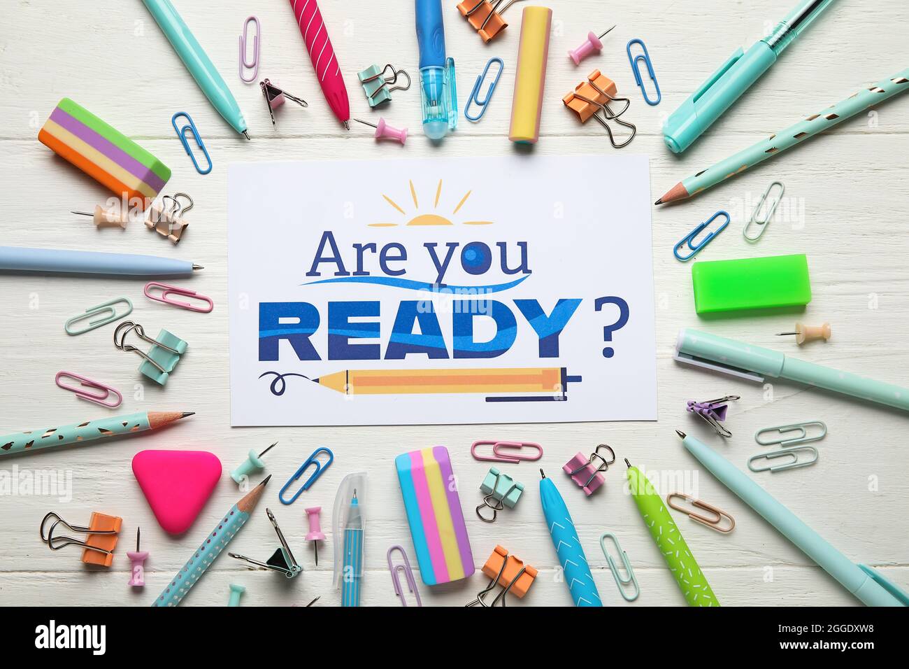 Paper sheet with text ARE YOU READY and stationery on white wooden ...