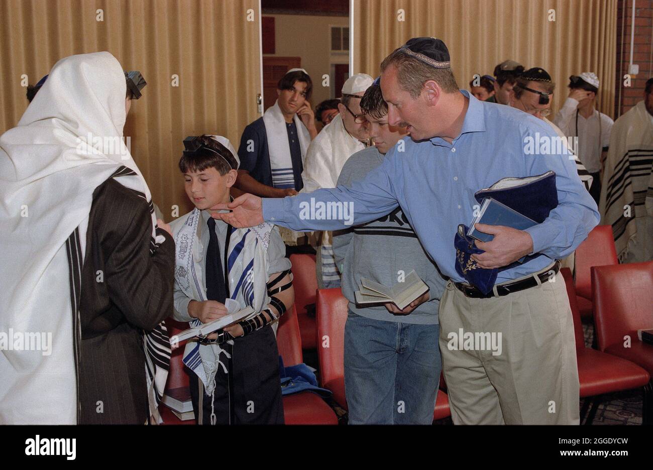Wishing the Barmitzvah boy success a congregant gives a friendly ...