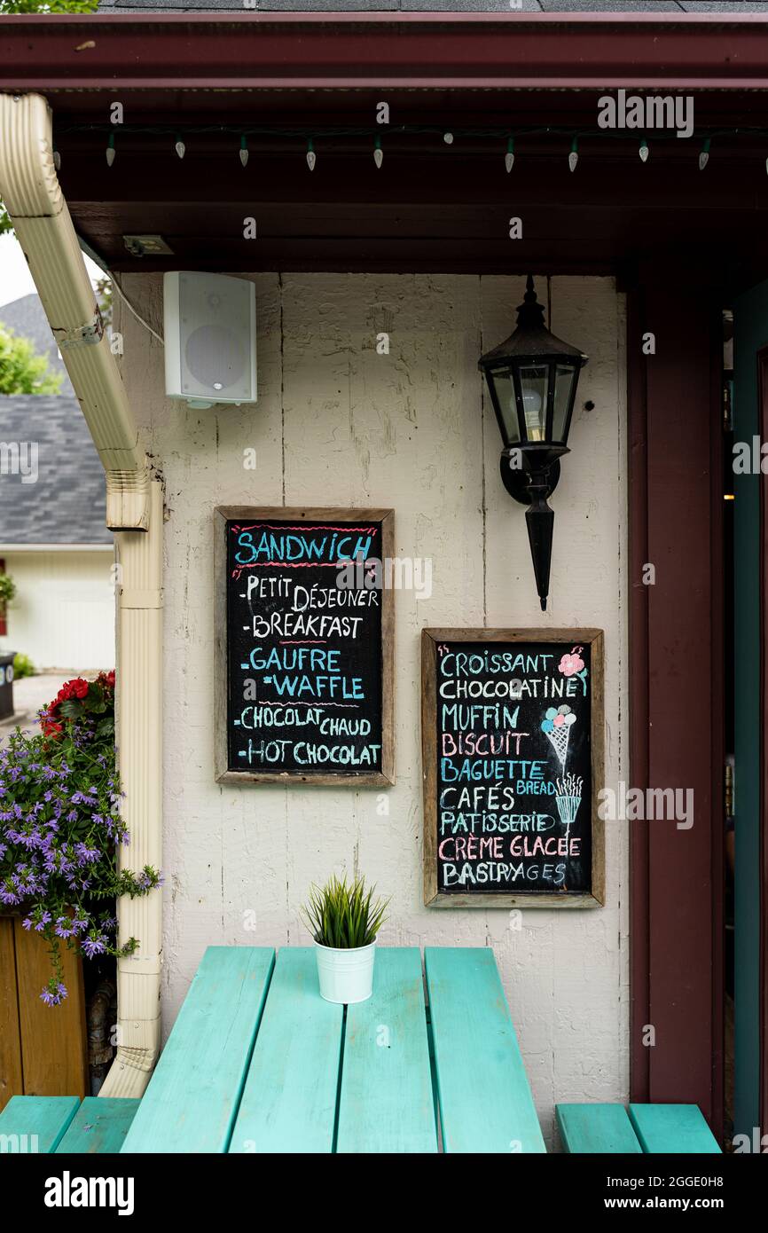 Vertical shot of cafe menu frames attached to a wall near the table ...