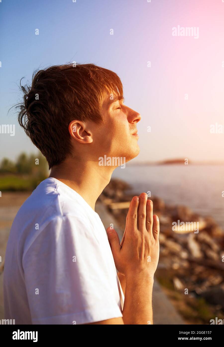 Young Man praying on the Nature Background Stock Photo - Alamy