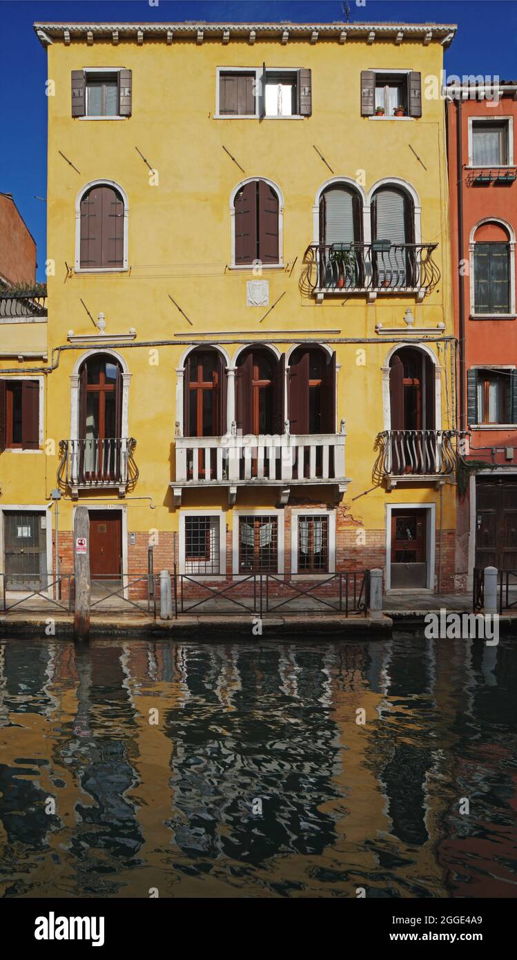 Traditional colorful canal building in Venice, with ornate balconies ...