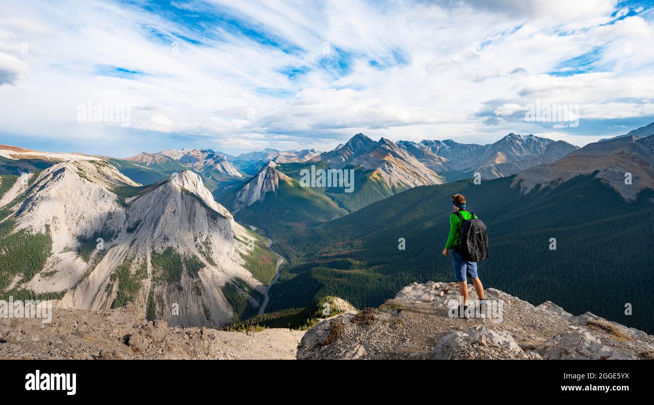 Hiker looking into the distance, mountain landscape with river valley ...