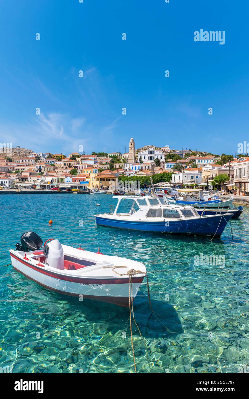 Fishing boats in the harbour of Halki with turquoise water, promenade ...