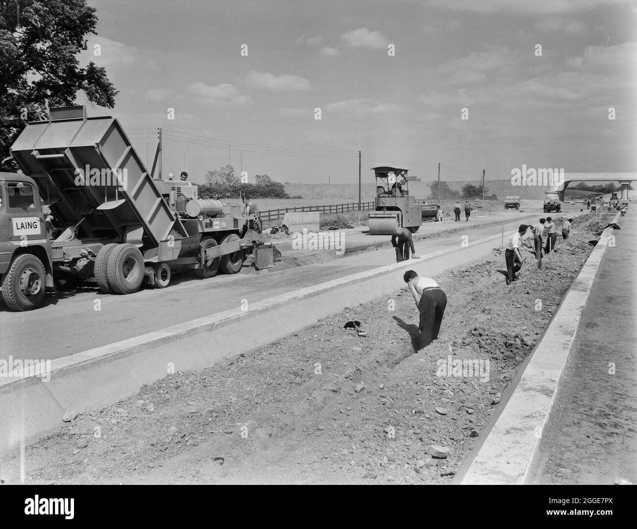 Construction machines laying a dry-lean concrete base in Section D4 of ...