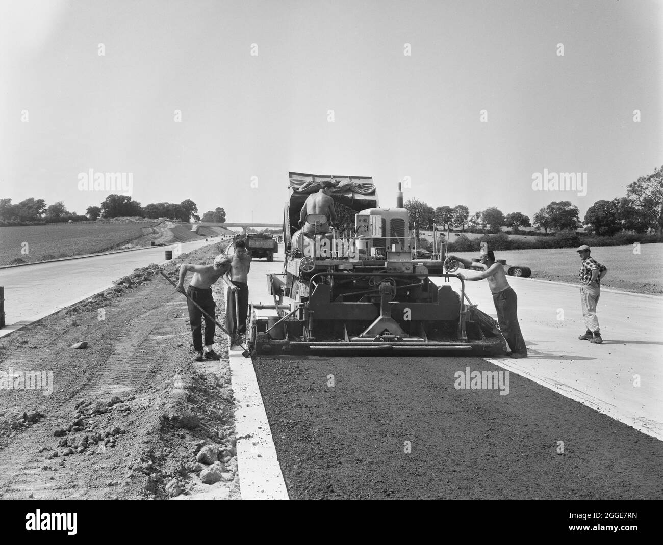A view of Laing workers operating a paver machine, laying an asphalt ...
